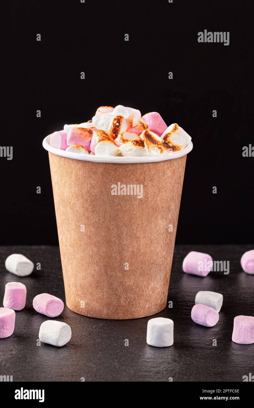 Paper cup with hot drink with marshmallows on dark background ...