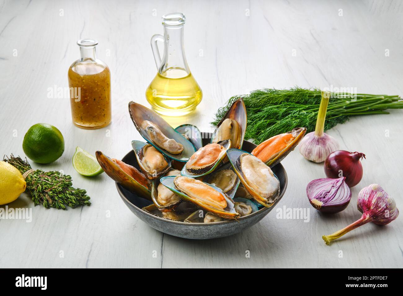 Plate with raw large mussels in half shell with spice on wooden table ...