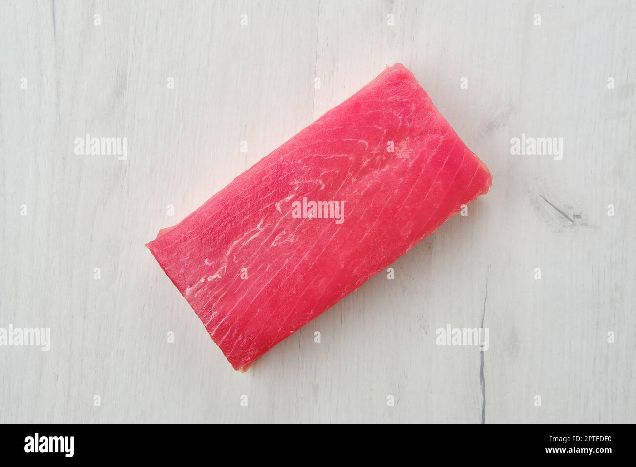 Raw frozen tuna fillet on wooden background Stock Photo - Alamy