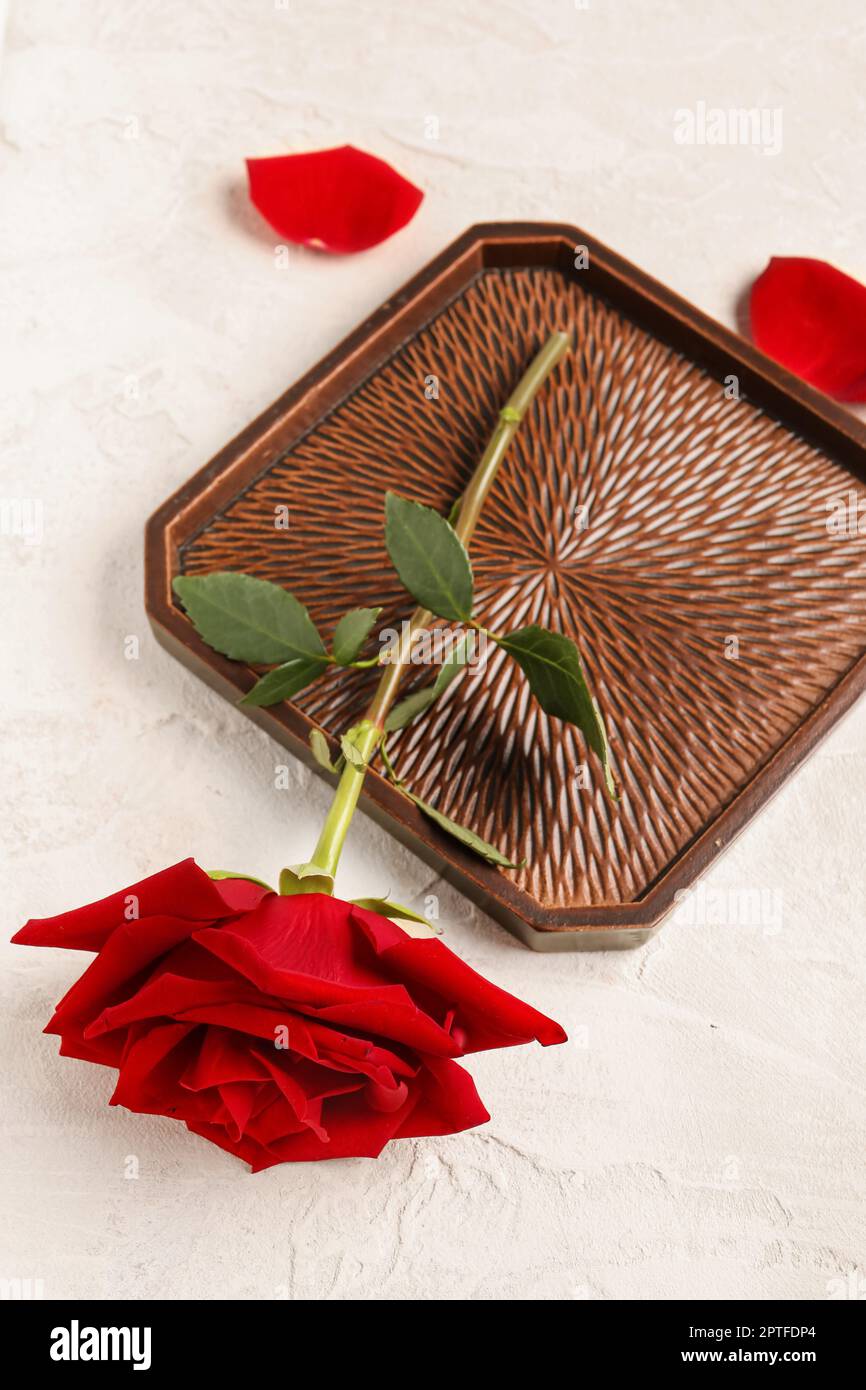 Tray with beautiful red rose and petals on light background Stock Photo ...