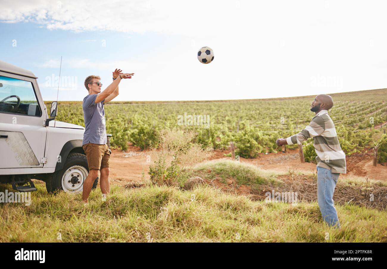 Nature. soccer and men throw a football on a road trip travel break in ...