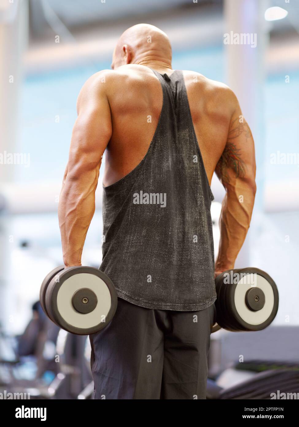 His determination is his strength. a male bodybuilder lifting weights ...