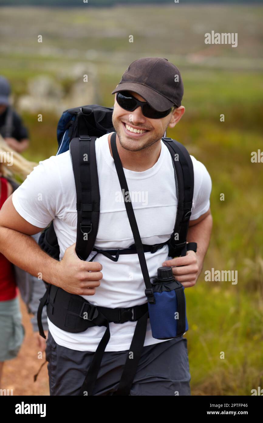 Hiking brings him closer to nature. A happy group of friends walking ...