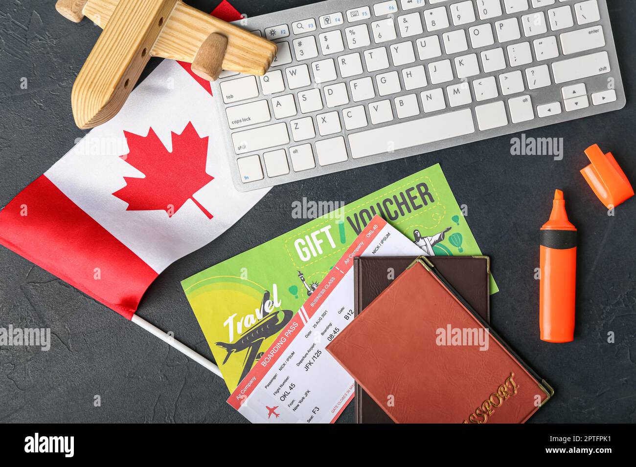 Canadian flag with wooden airplane, ticket, passports and computer ...