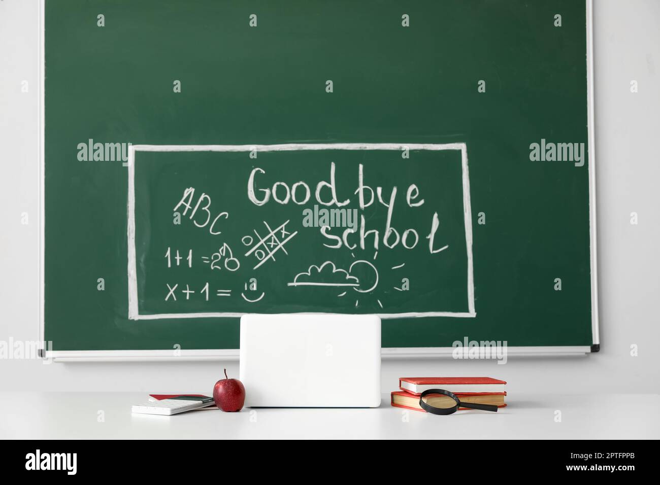 Blackboard with text GOODBYE SCHOOL, drawings and teacher's table in ...