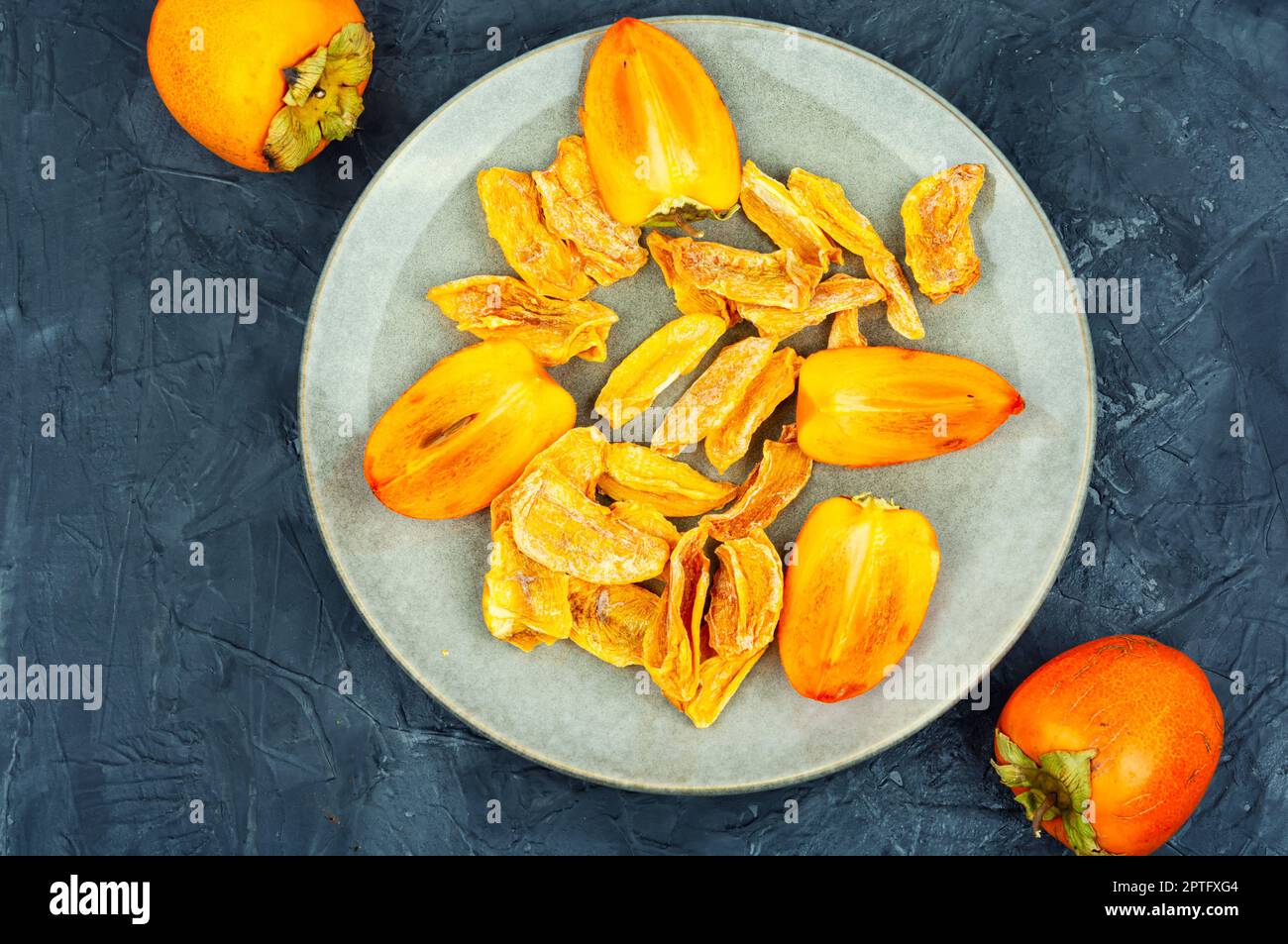 Dried persimmon fruits with fresh persimmon. Vegan snacks Stock Photo ...
