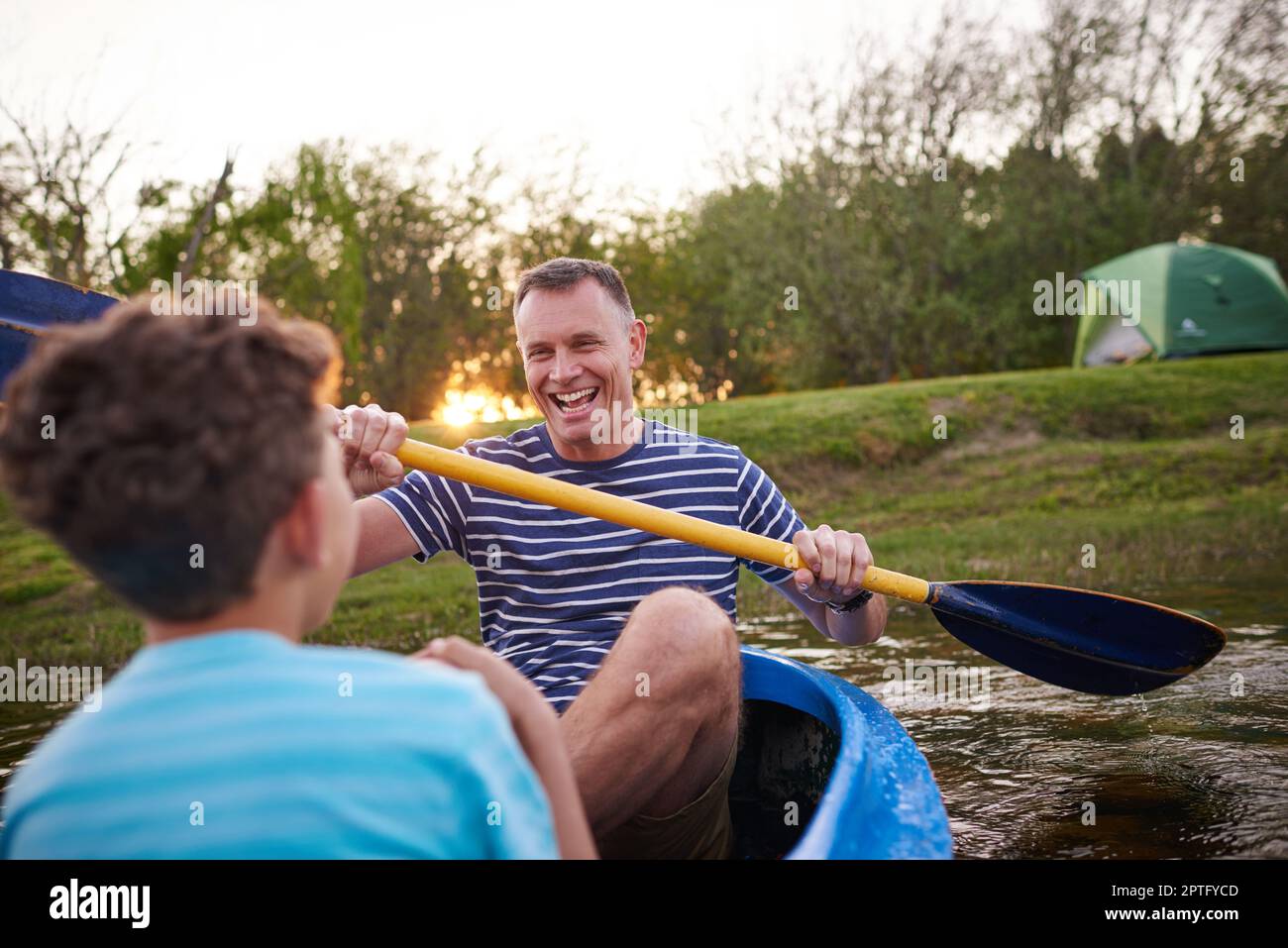 Lets head back to shore. a father and son rowing a boat together on a ...