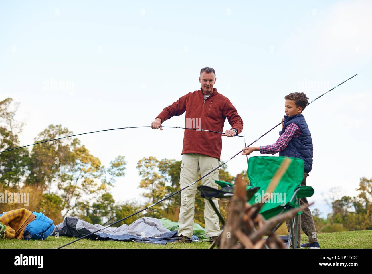 Setting up camp. a father and son setting up a tent together while ...