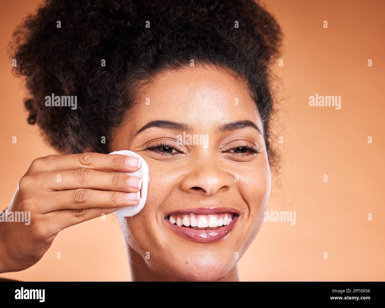 Face, skincare and black woman with cotton pad on orange studio ...