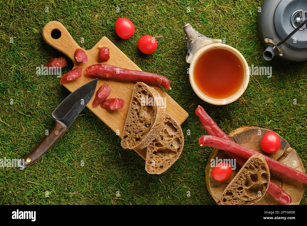 Top view of snack in the woods with dried thin sausage, bread and ...