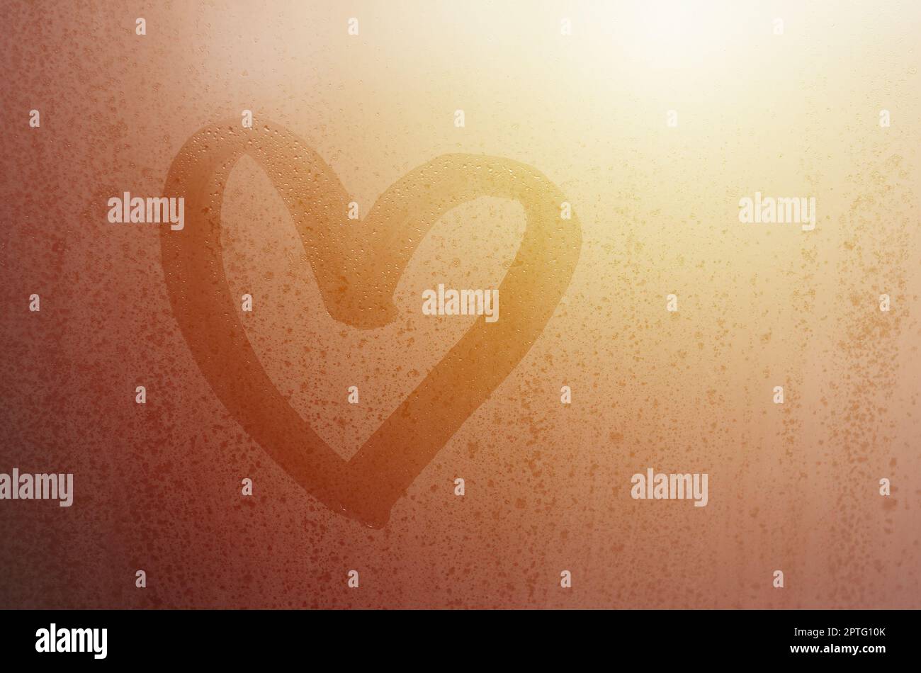 Love heart shape hand drawn on wet, frozen window pane with morning ...