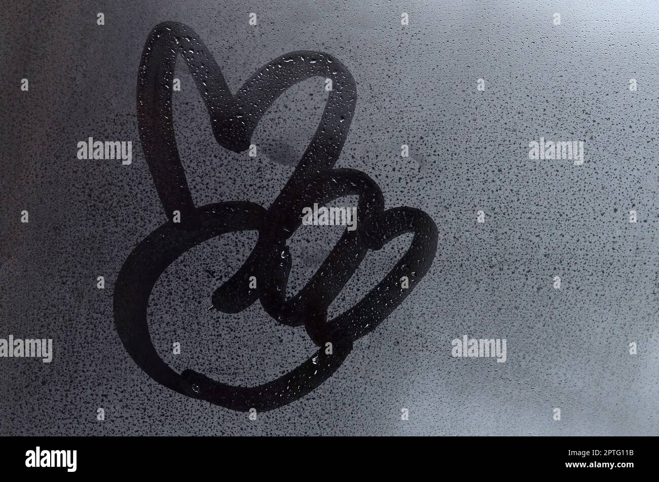 The image of the peace symbol is drawn with a finger on the surface of ...