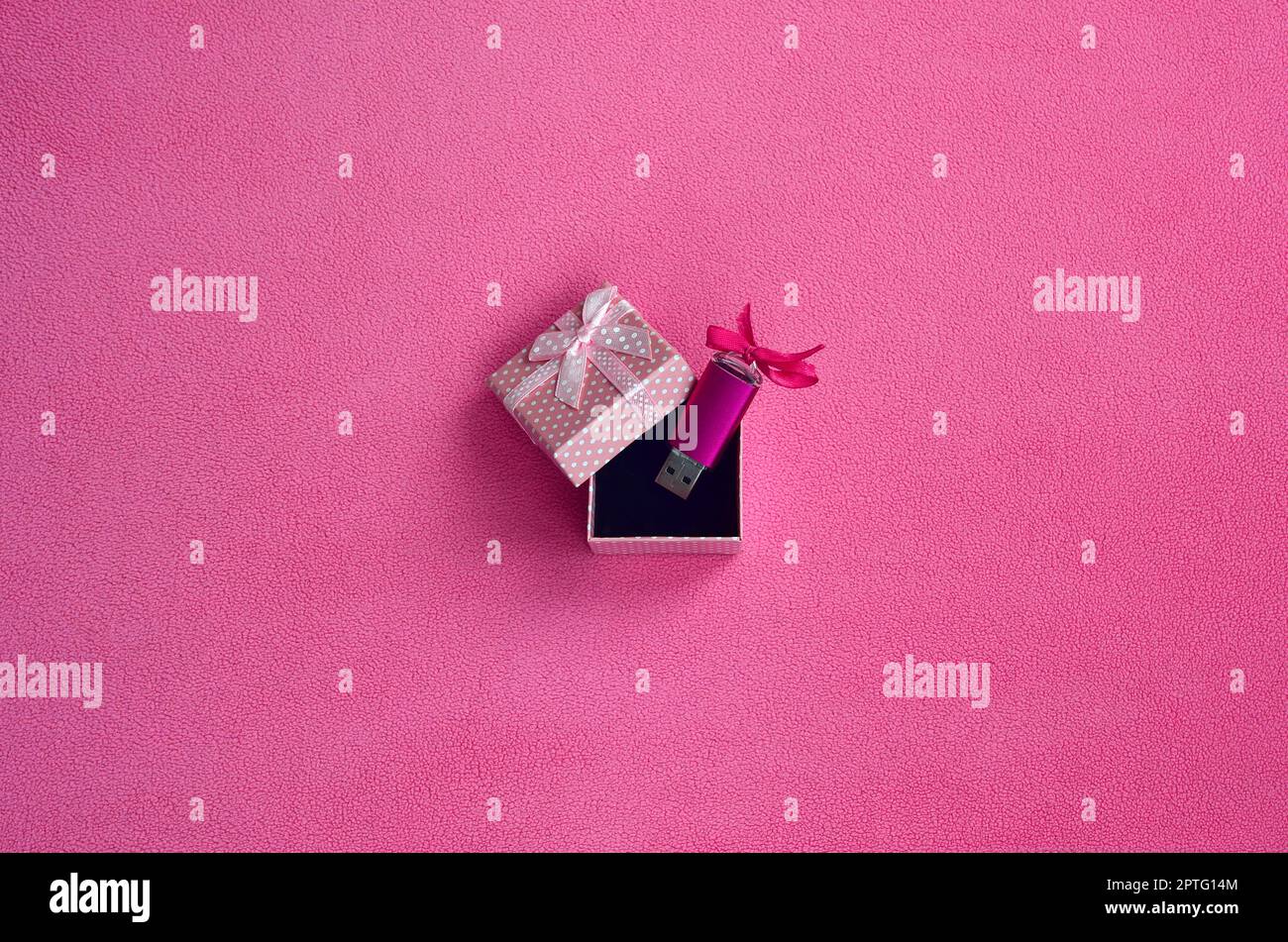 Brilliant pink usb flash memory card with a pink bow lies in a small ...