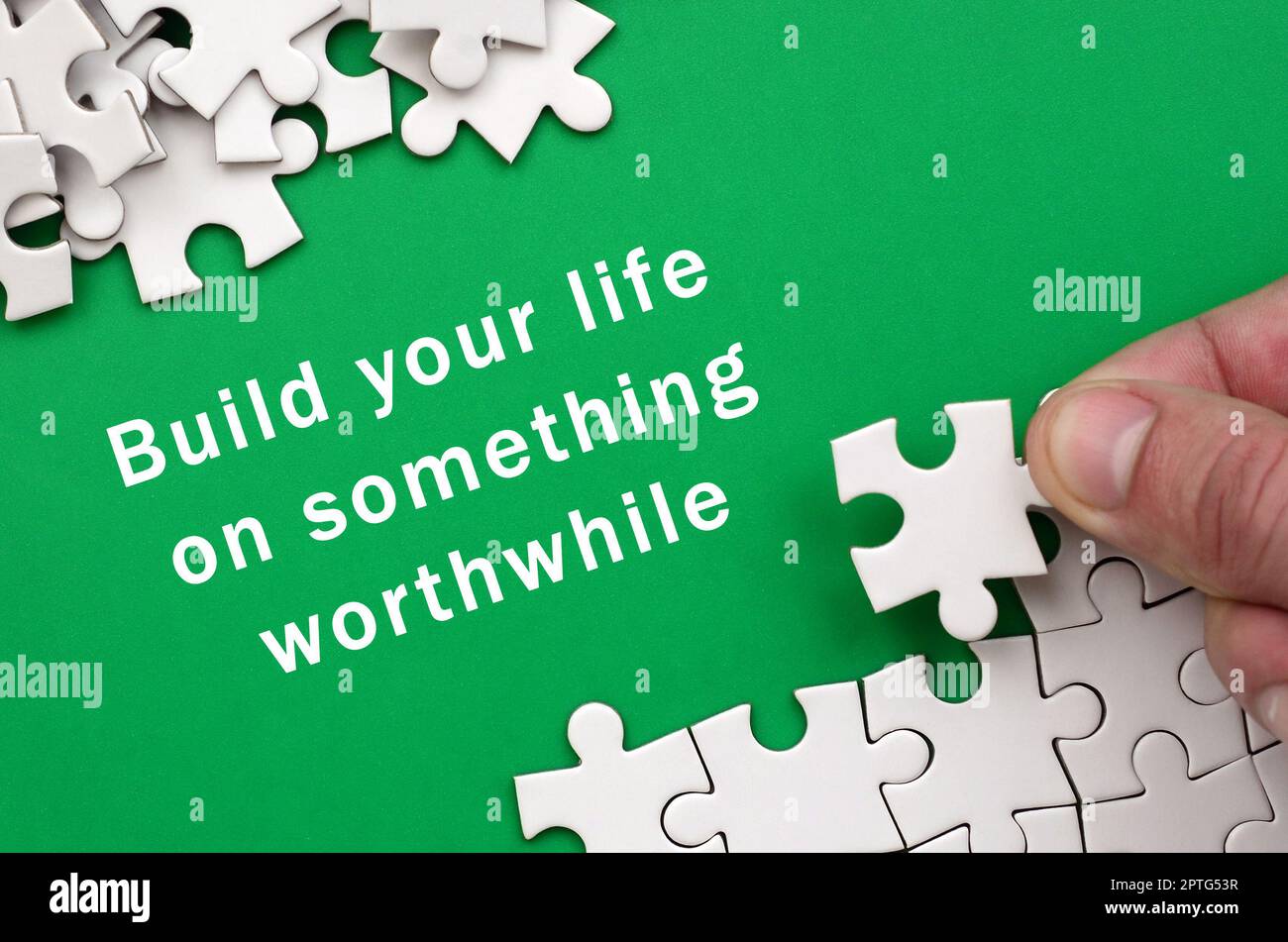 Build your life on something worthwhile. The hand folds a white jigsaw ...
