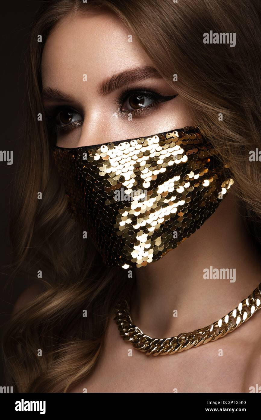 Portrait of a beautiful woman in a gold mask with sequins and classic ...