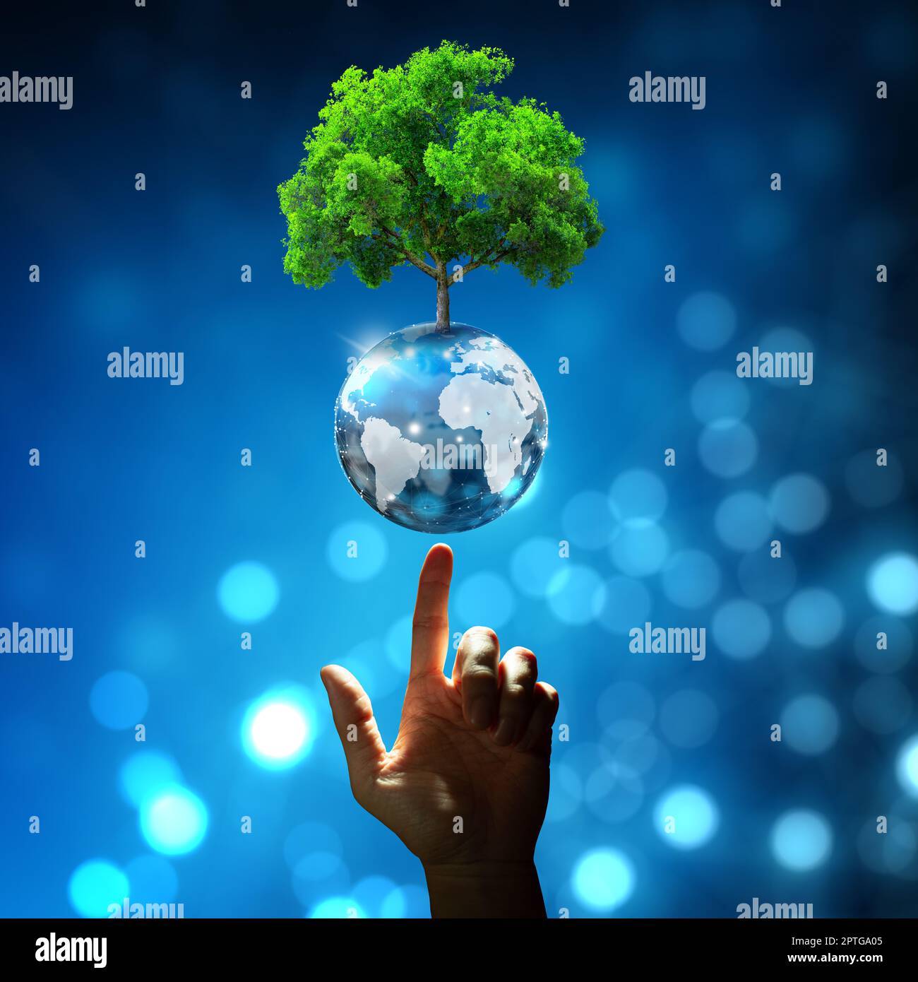 Hand pointing growing tree on crystal ball with technological ...