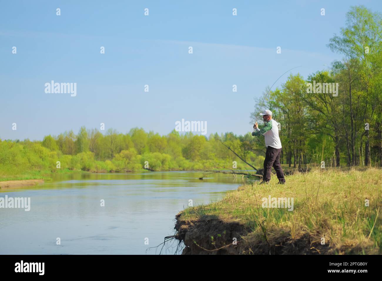 Fisherman throwing the bait with a spinning rod. Outdoor weekend ...