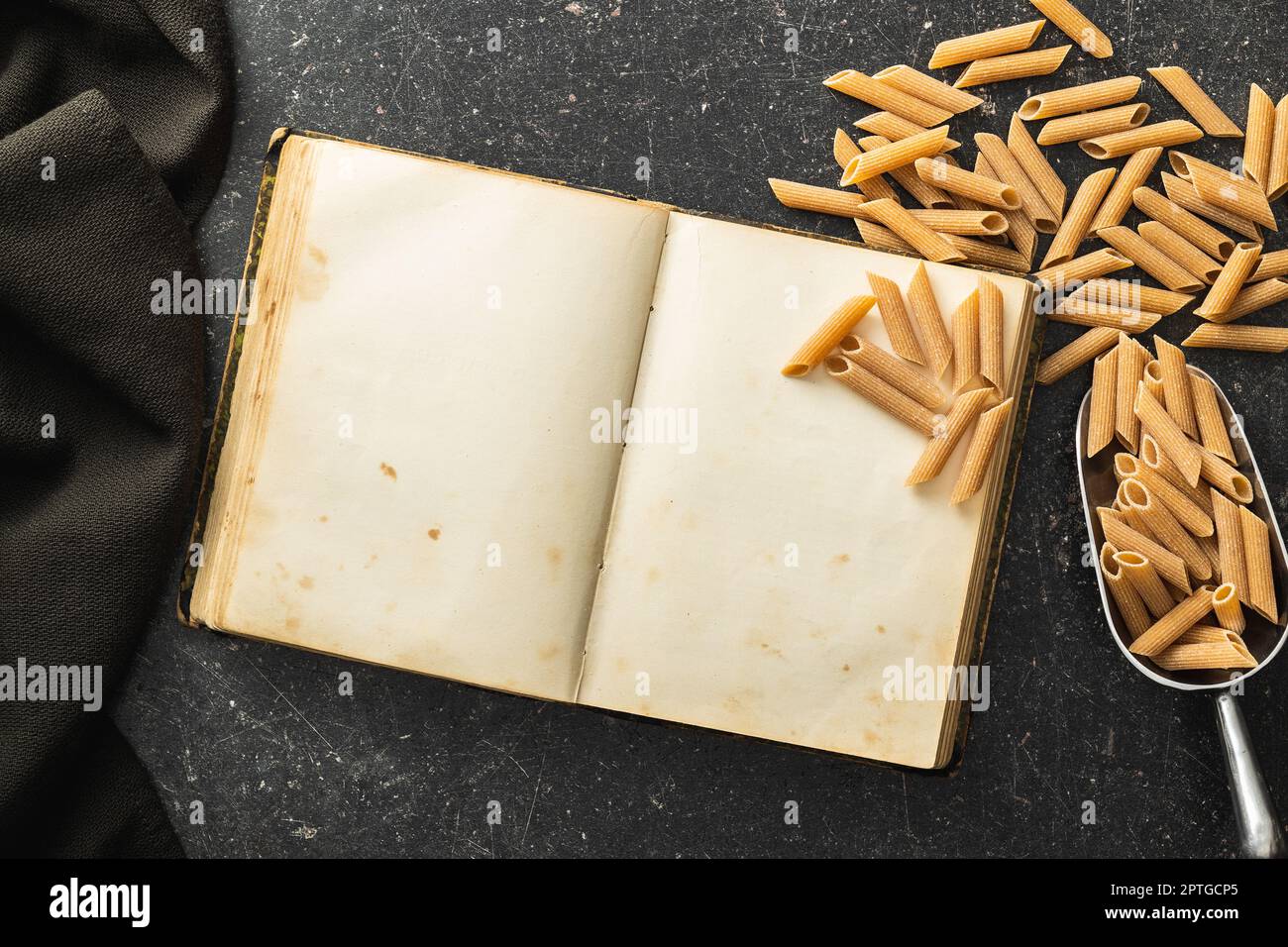 Blank cookbook and uncooked whole grain pasta. The raw penne pasta. Top ...