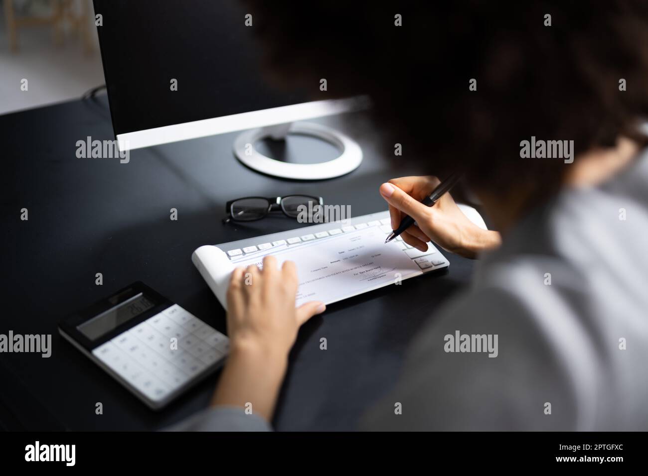 African Woman Signing Bank Check Or Paycheck Stock Photo - Alamy