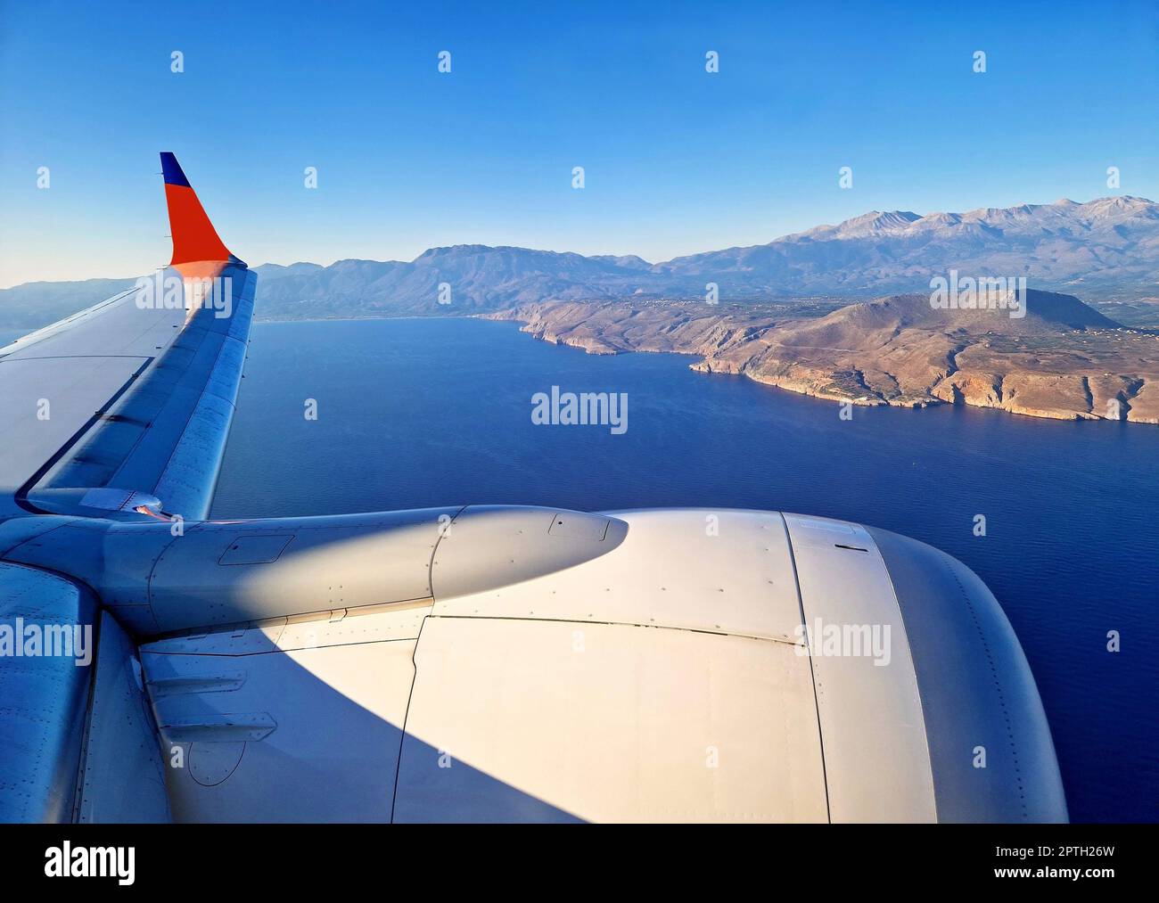 A view of Crete shore through airplane window during landing. View from ...