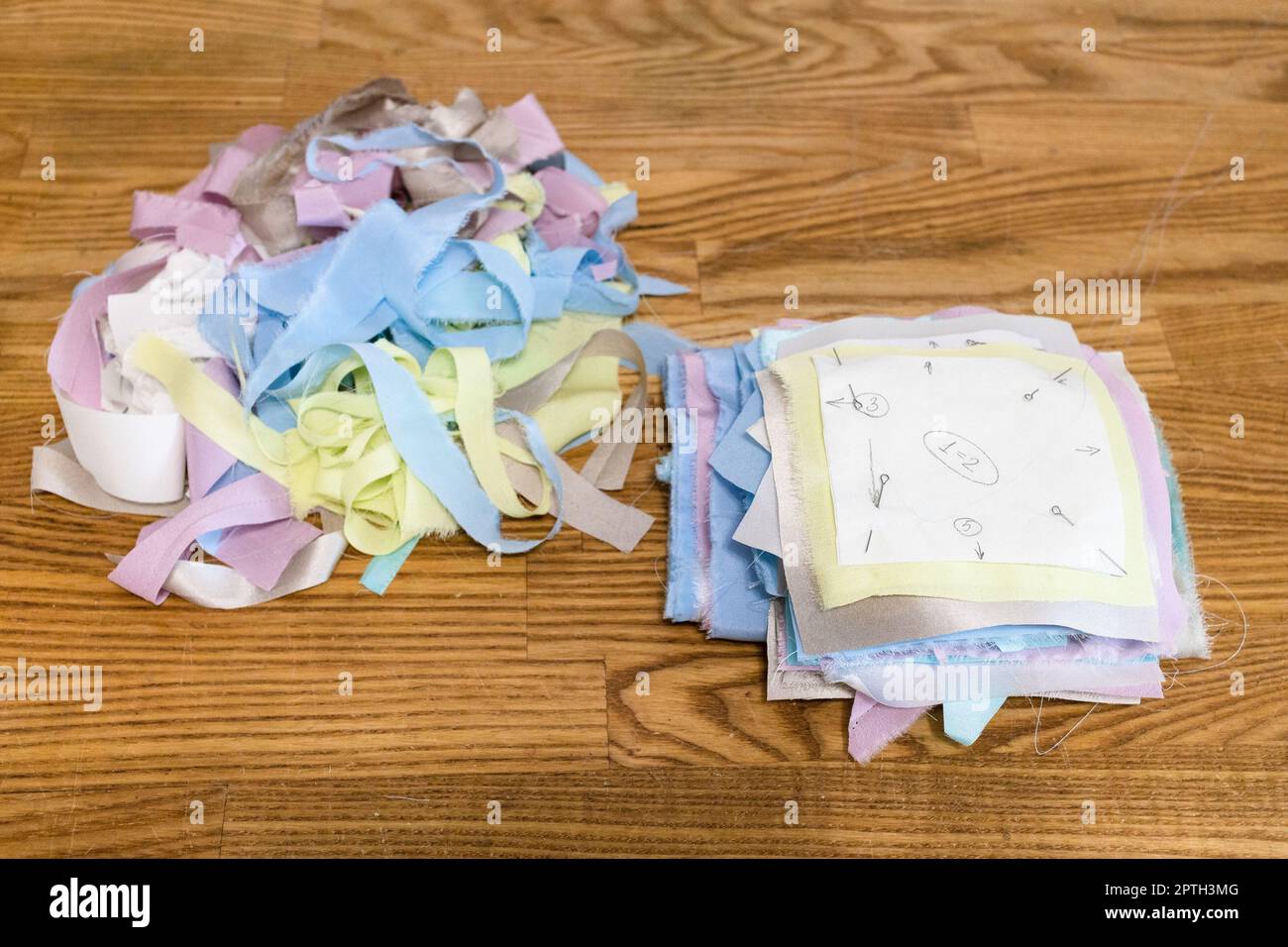 heap of cut-out pieces of silk fabrics with fixed paper patterns ...