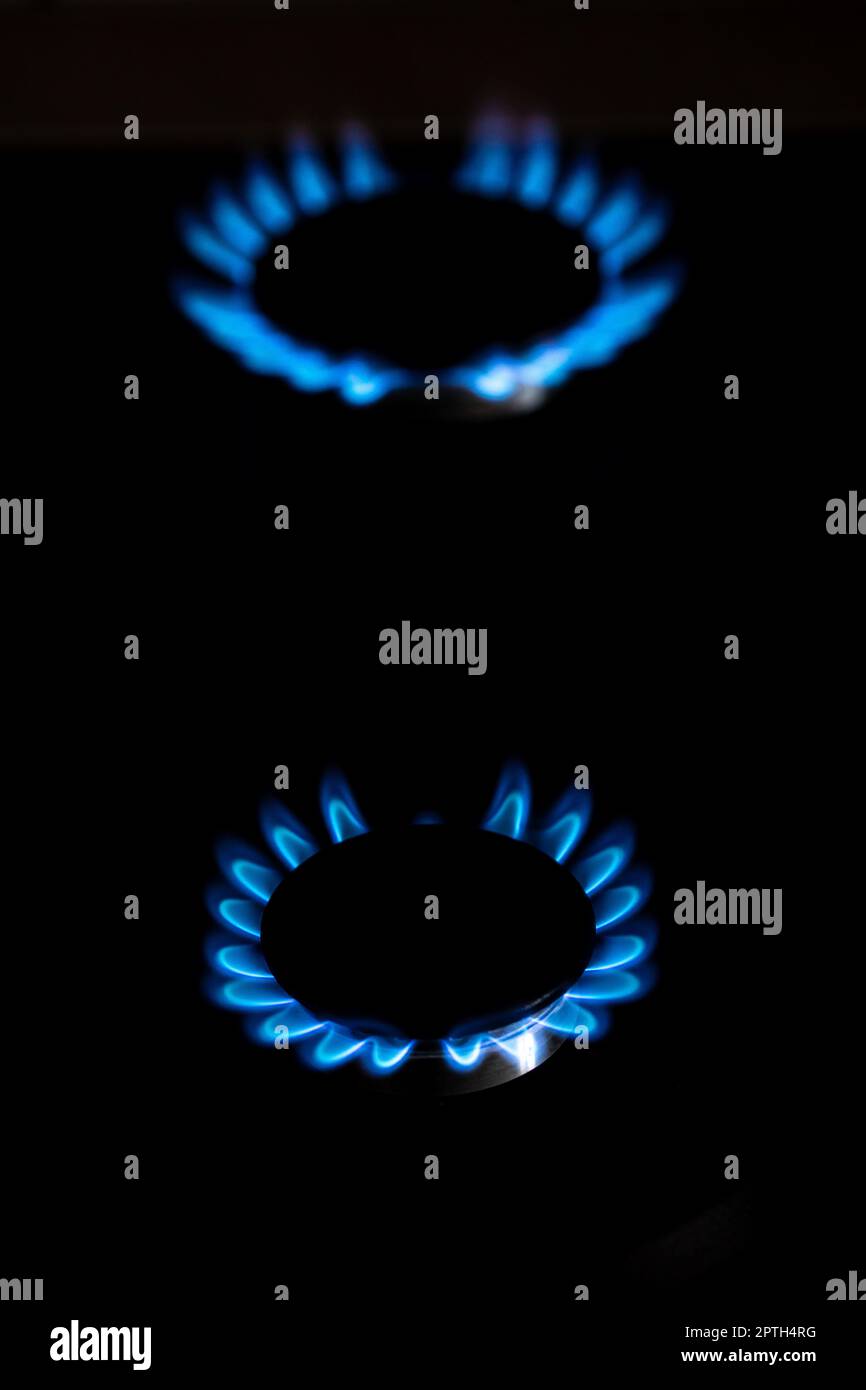 Closeup shot of blue fire from domestic kitchen stove top. Burning gas ...