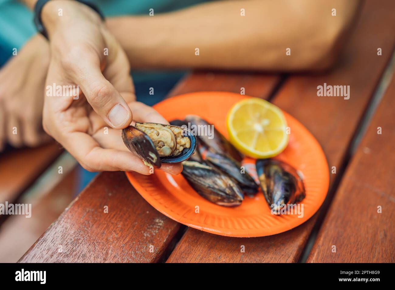 Heap of mussels in shells stuffed with rice. Man is going to eat midye ...