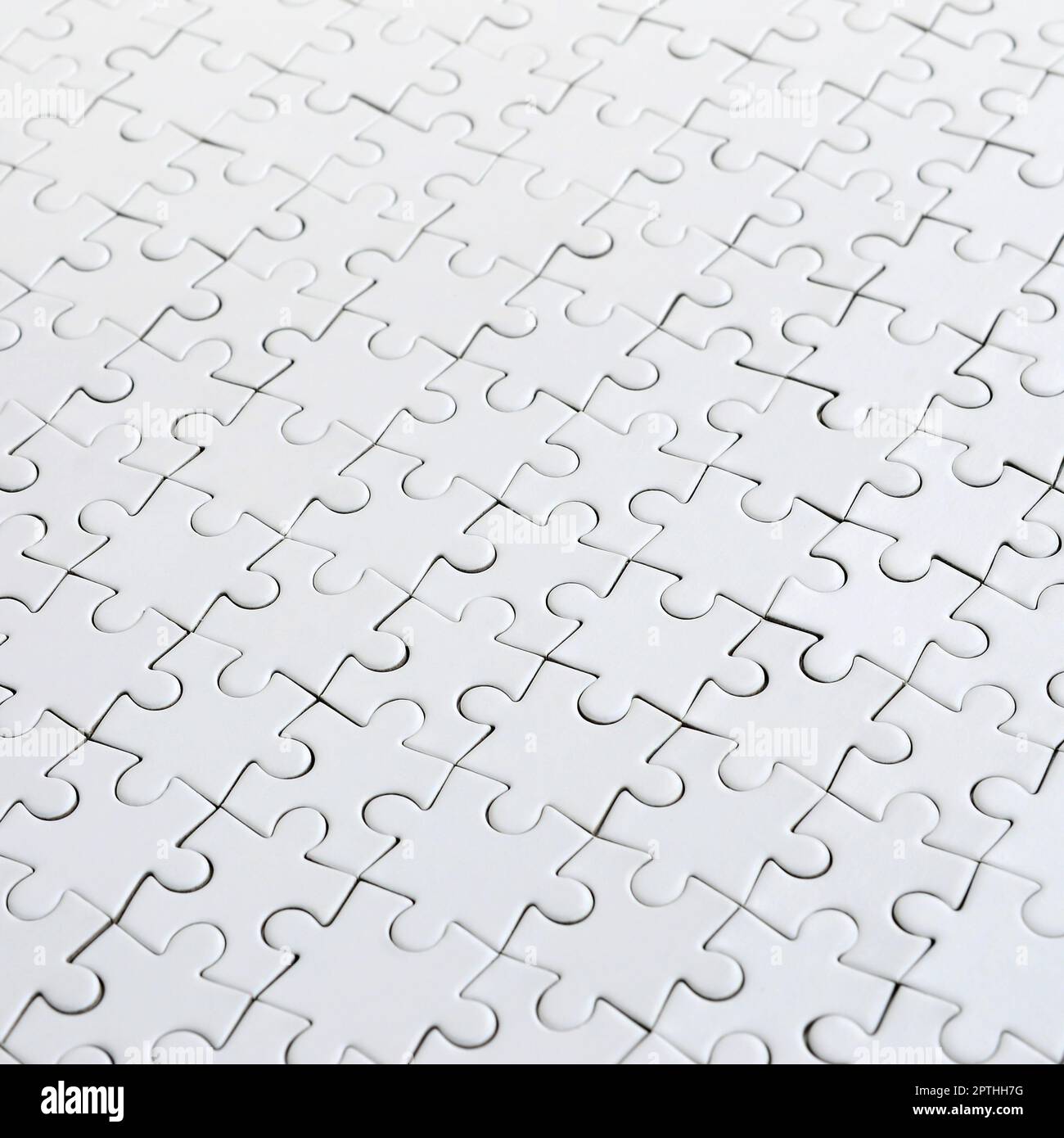 Close up of a white jigsaw puzzle in assembled state in perspective ...