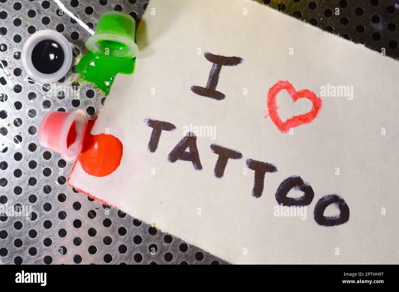 I love tattoo. The text is written on a small sheet of paper next to ...