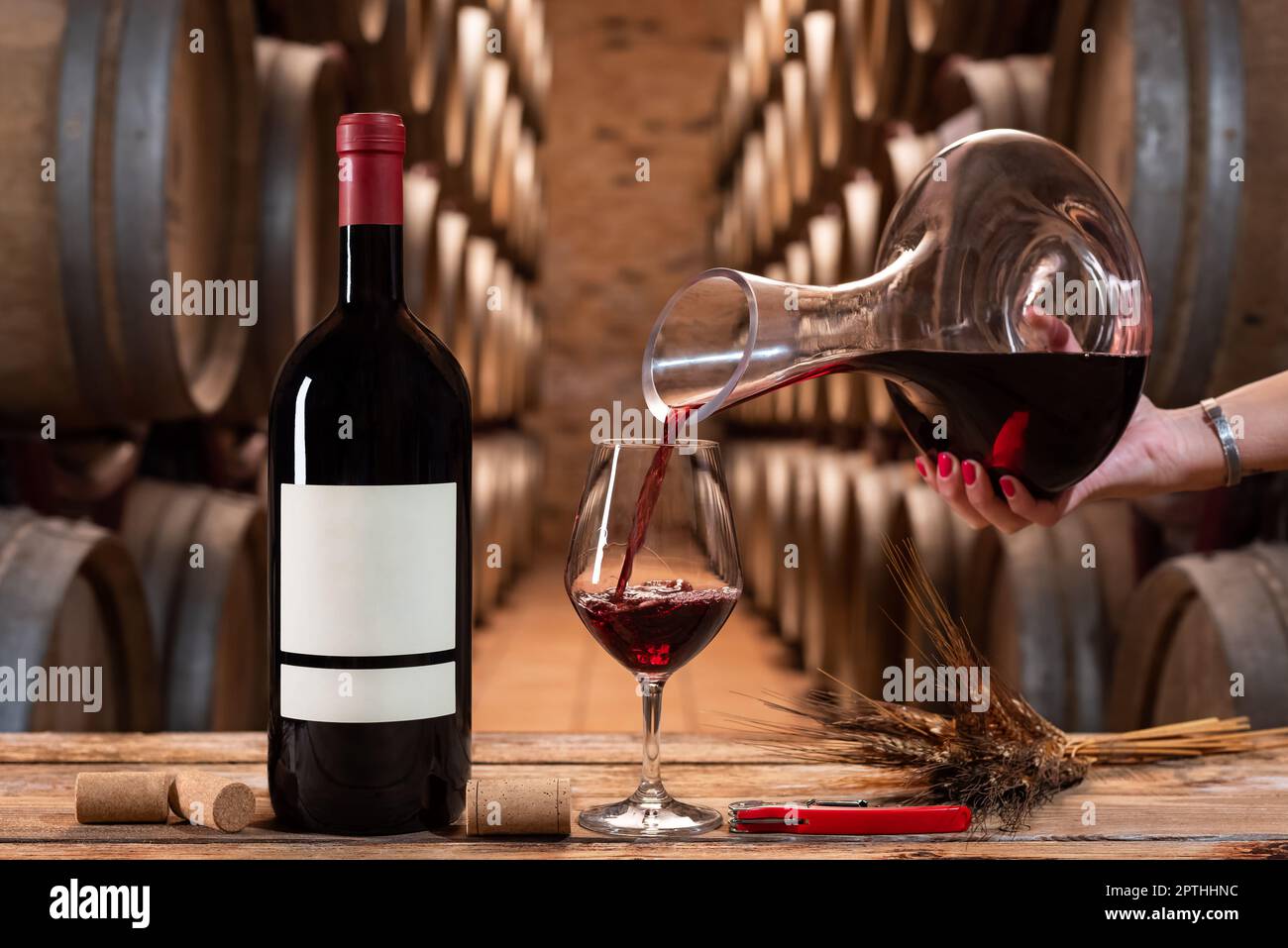 Winery. Pouring red wine from the decanter into the wine glass for ...
