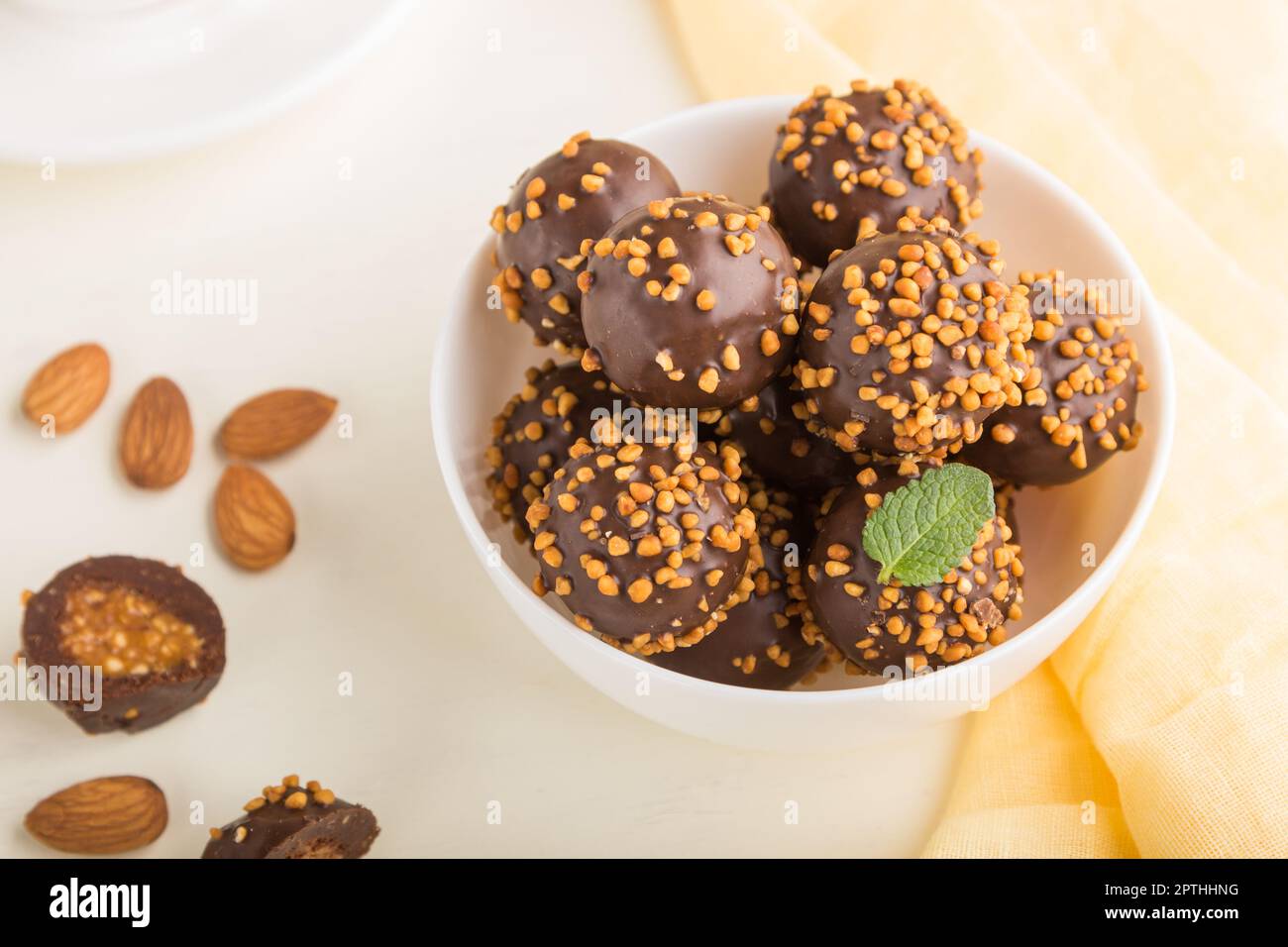Chocolate caramel ball candies with almonds and a cup of coffee on a ...