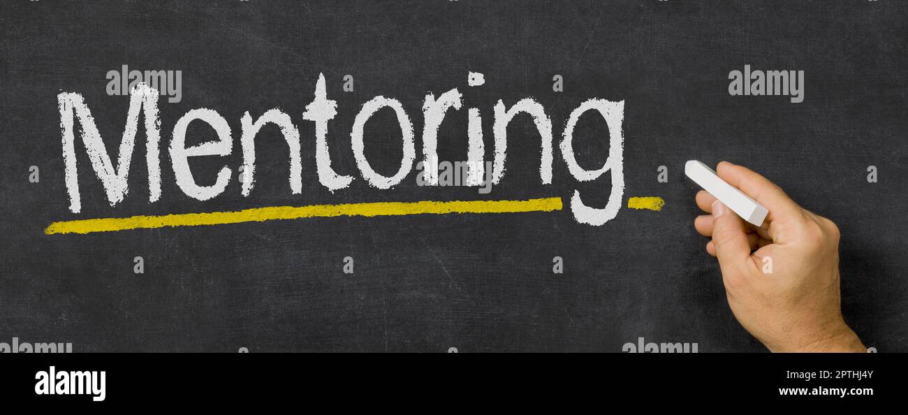 Text written on a blackboard - Mentoring Stock Photo - Alamy