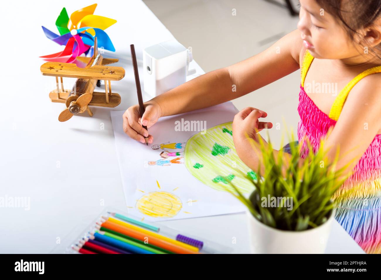 Asian cute kid preschooler sit on table smiling she draw picture with ...