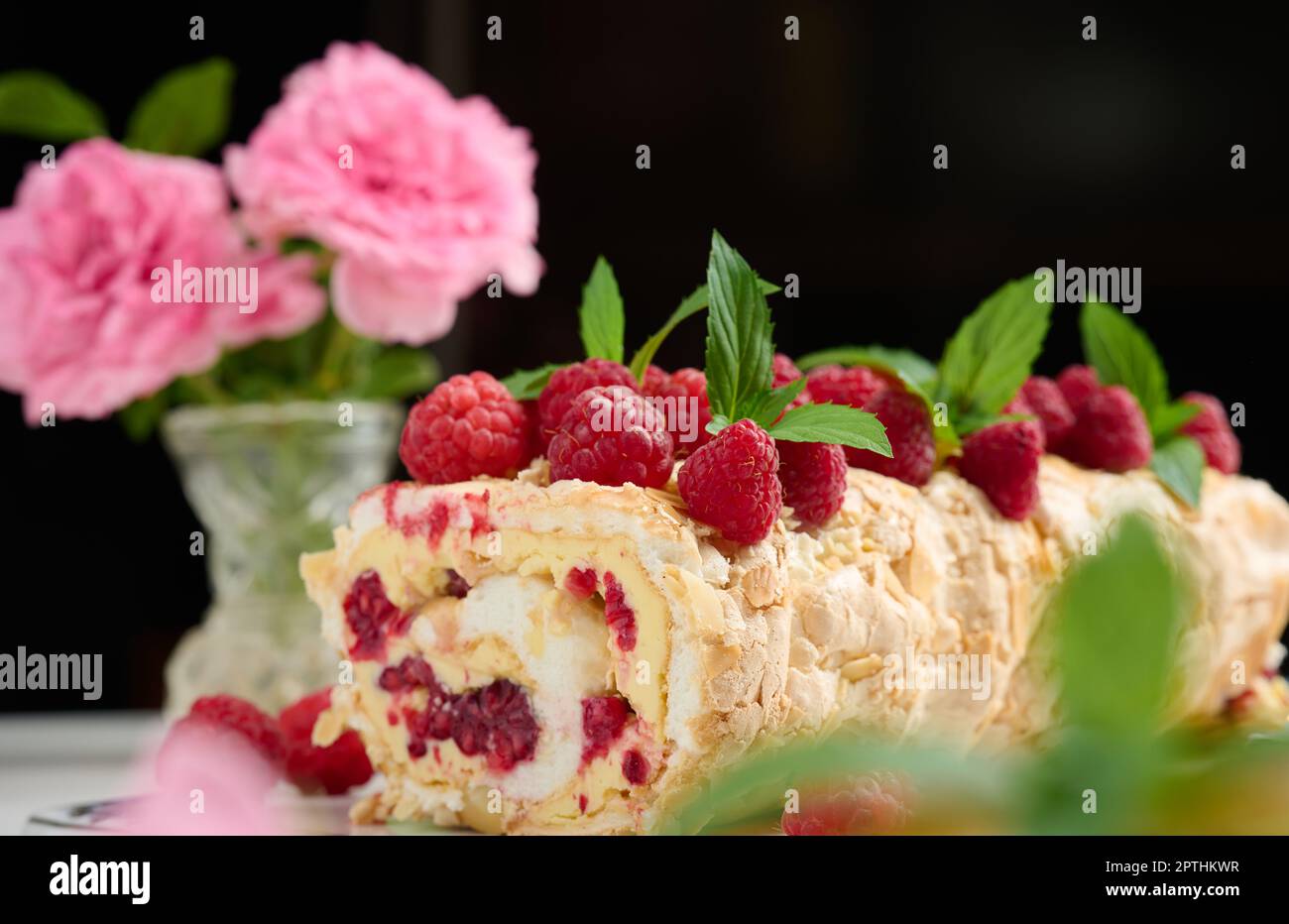 Baked meringue roll with cream and fresh red raspberry Stock Photo - Alamy