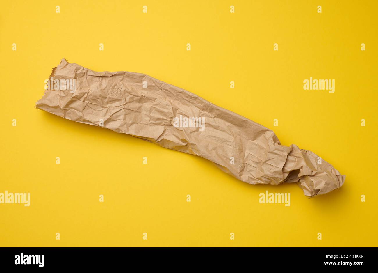 Empty oblong paper bag for a baguette on a yellow background, top view ...