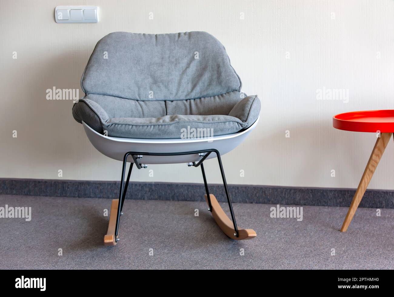 The rocking chair and table against the wall. Interior inside ...