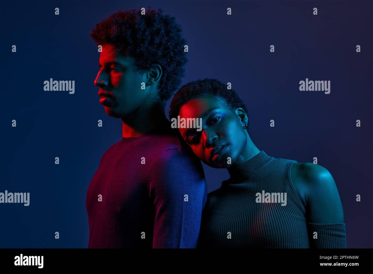 Woman leaned on man shoulder, young confident people in neon light over ...