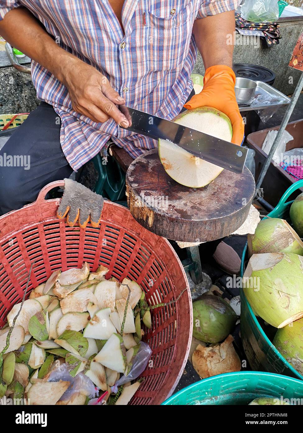 Hand man peeling coconut with knife Stock Photo - Alamy