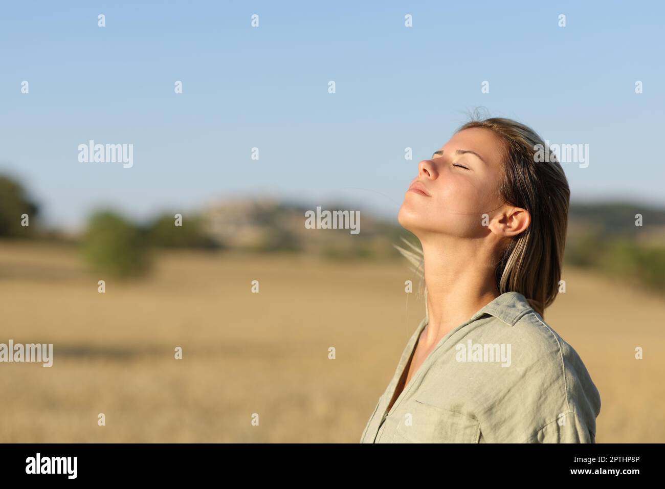 Beautiful woman breathing fresh air in a rural field Stock Photo - Alamy