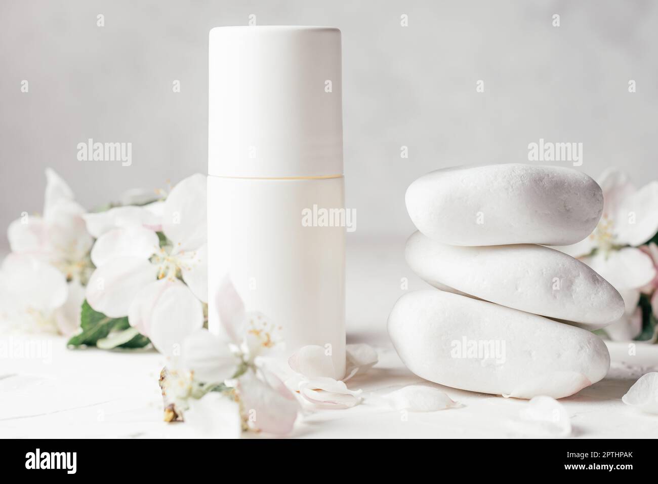Antiperspirant roll-on deodorant near stack of white pebble stones on ...