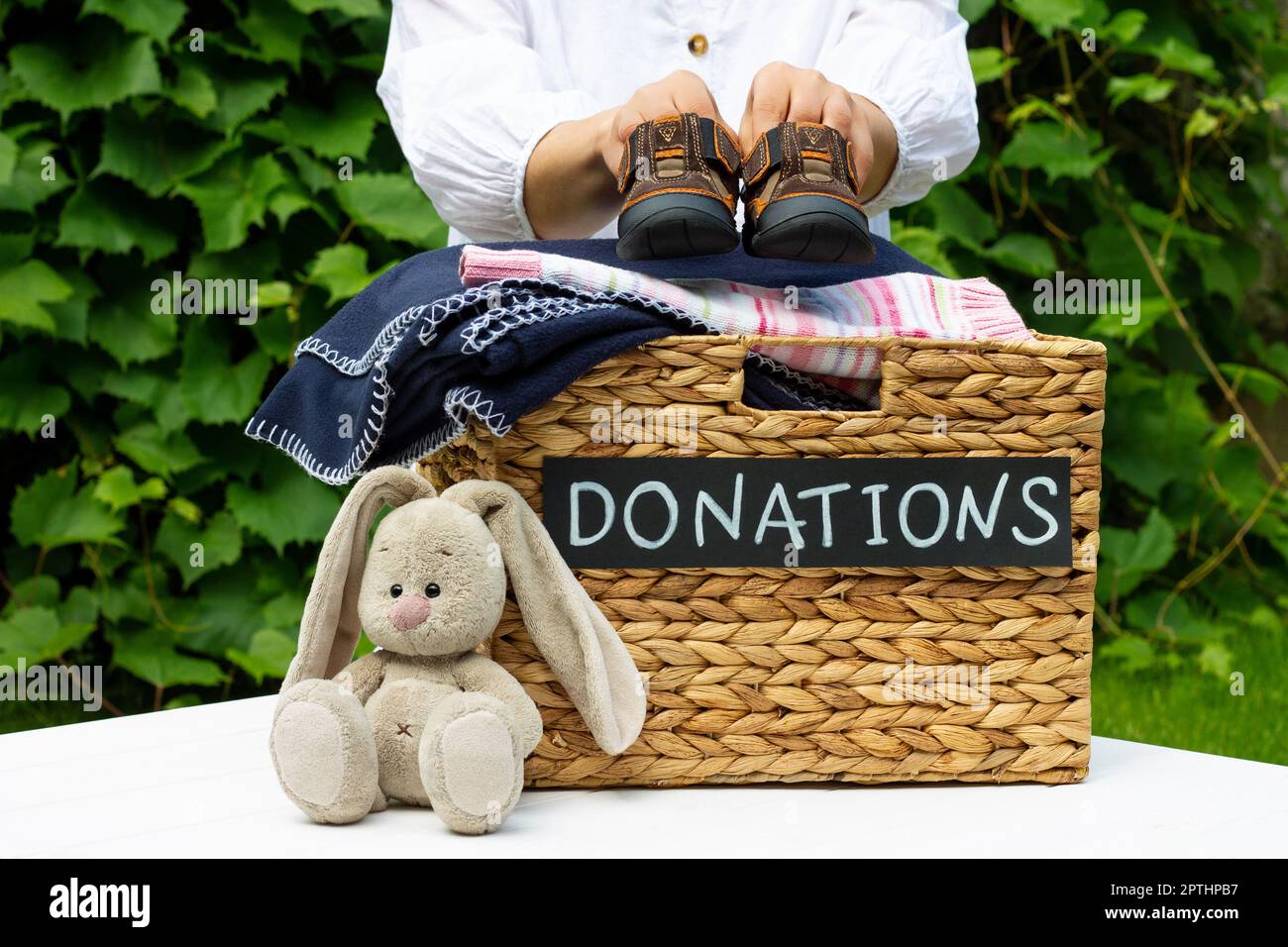 Hands putting a children shoes in a box for clothing donations on a ...