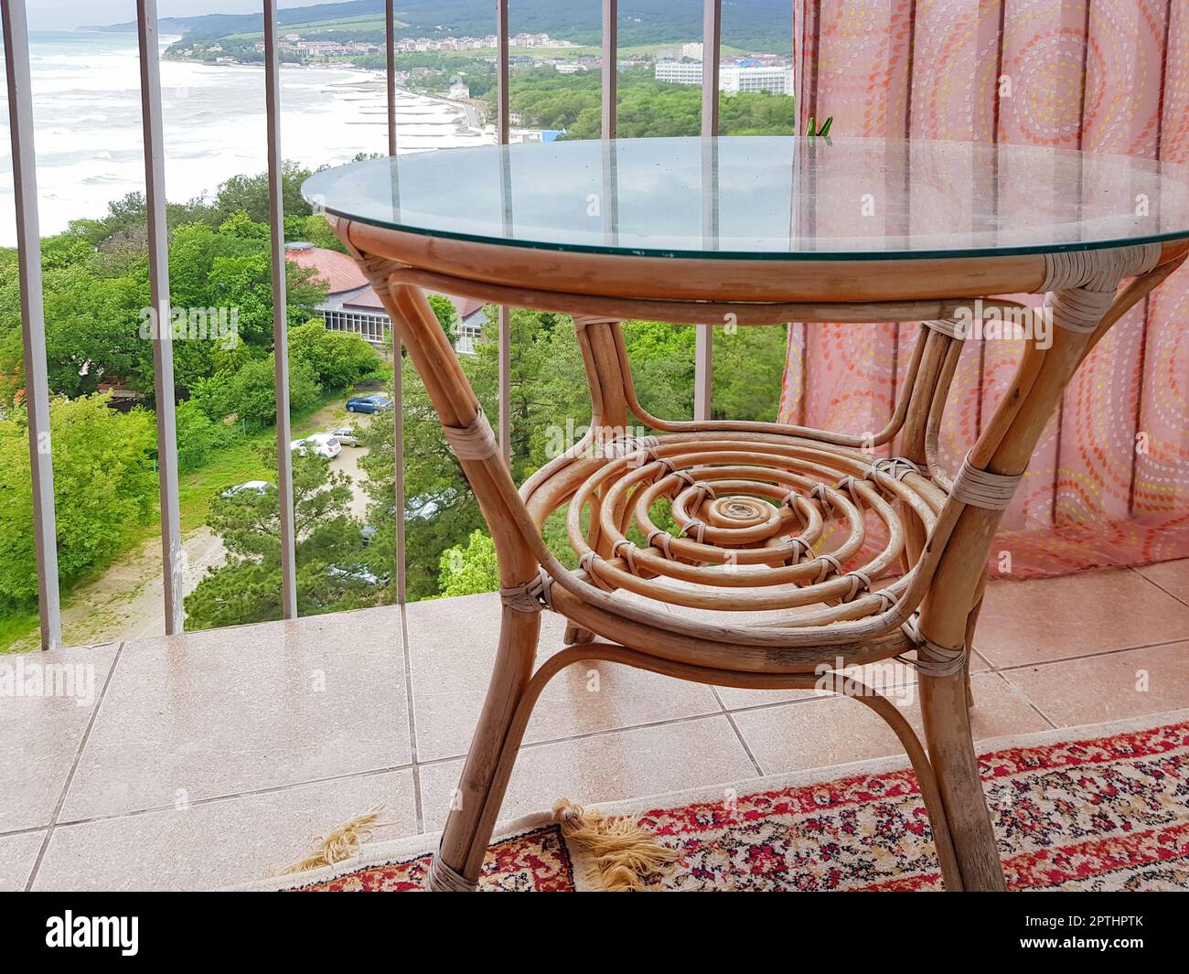 Interior of the balcony with a wicker table with a glass lid, view from ...