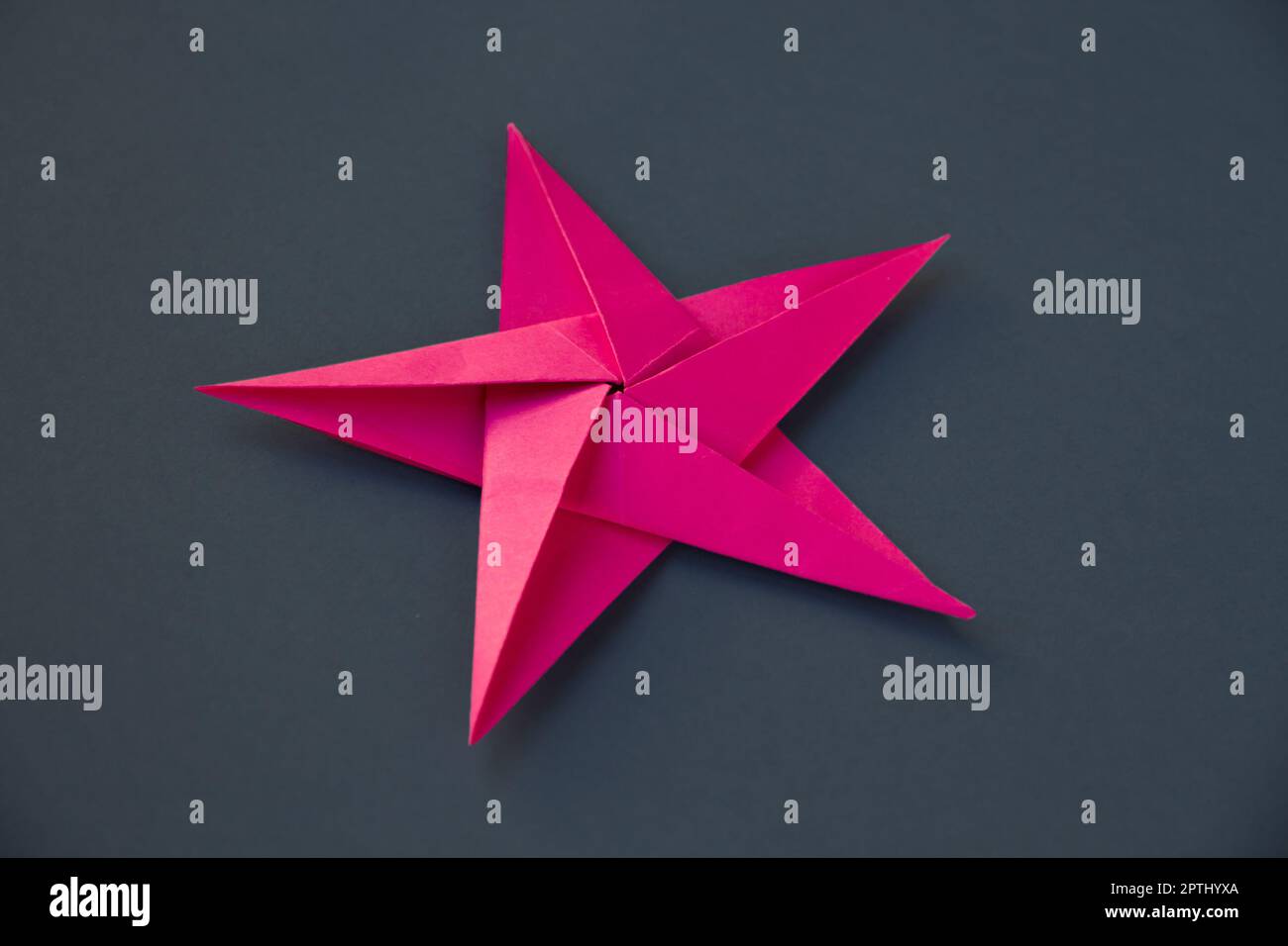 Pink paper star origami isolated on a blank grey background Stock Photo ...