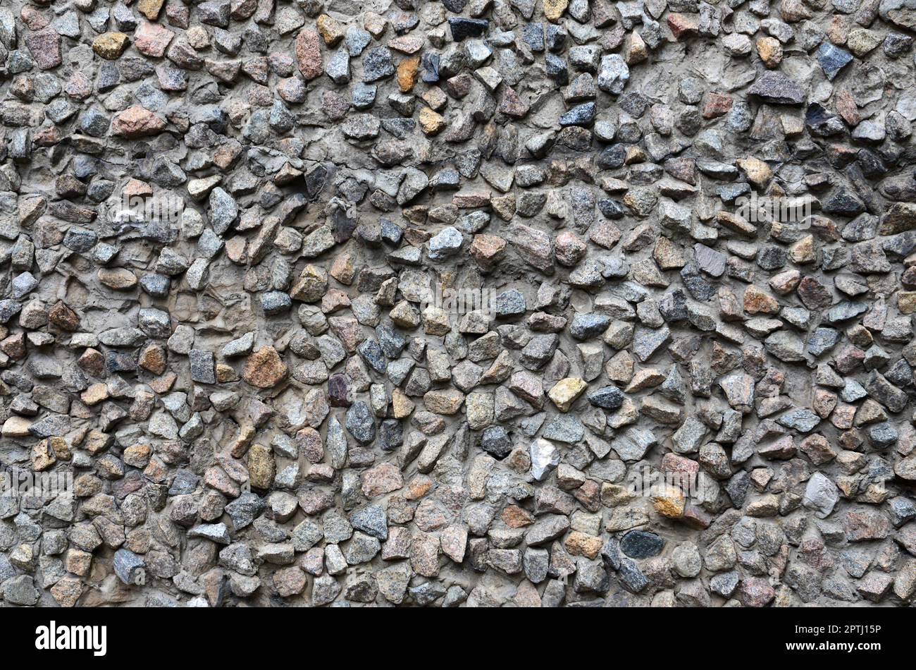 The texture of a strong stone wall of many concreted stones of various ...