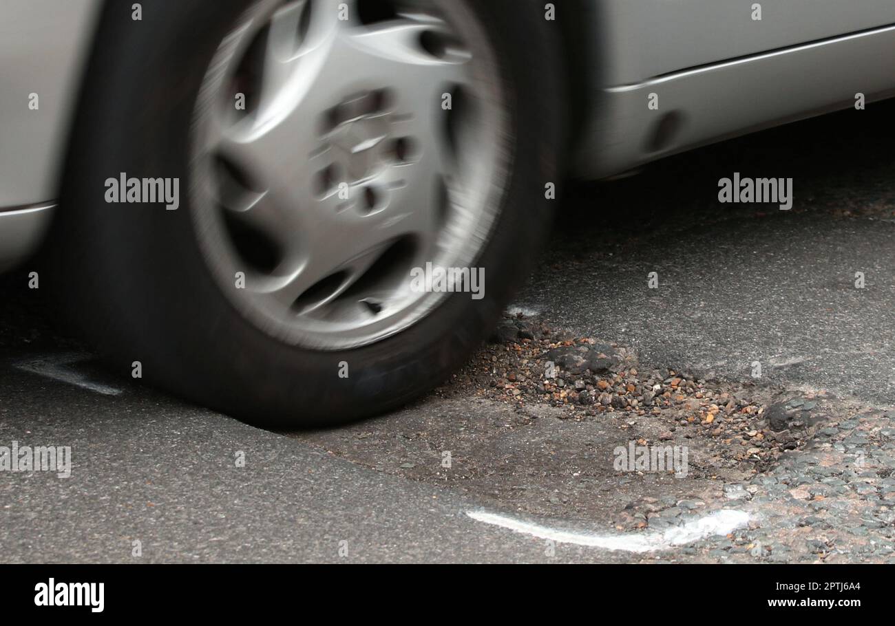 File photo dated 11/05/18 of a car hitting a pothole on a road. Drivers ...
