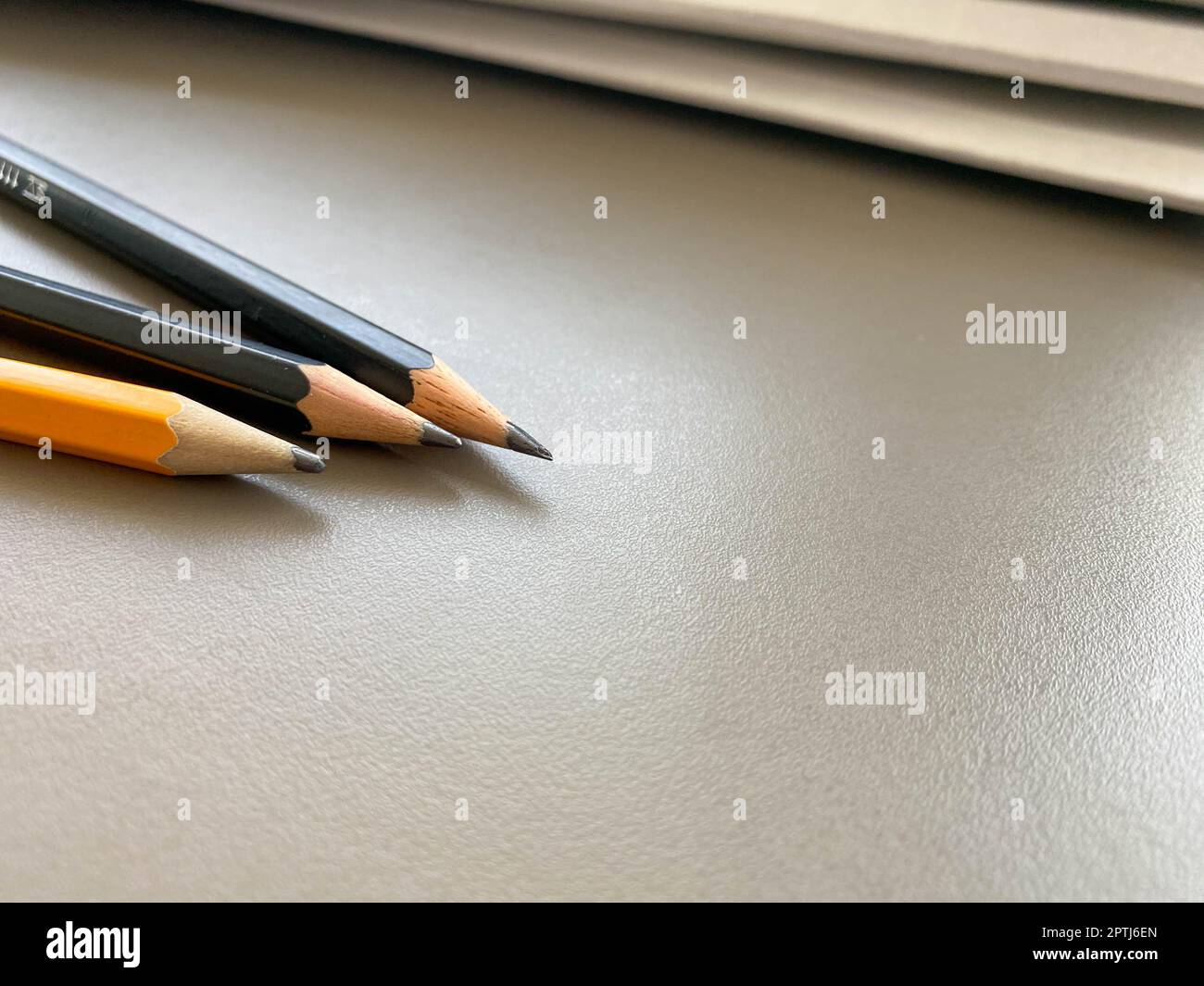 Three pencils lie sharply sharpened next to folders with sheets of ...