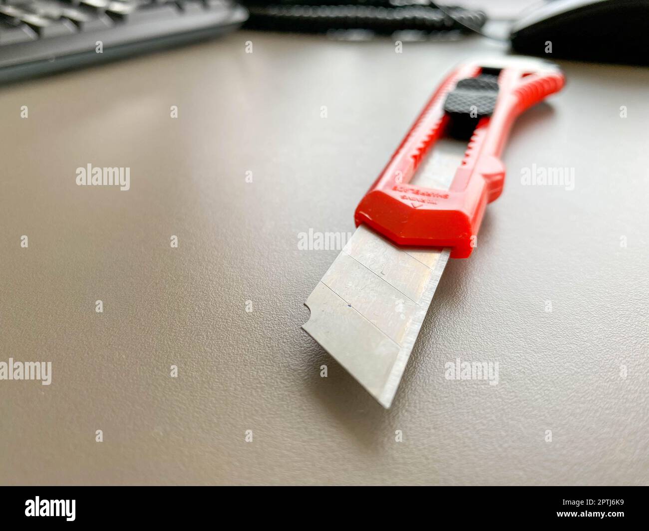 stationery on the table in the office. stationery knife with a red ...