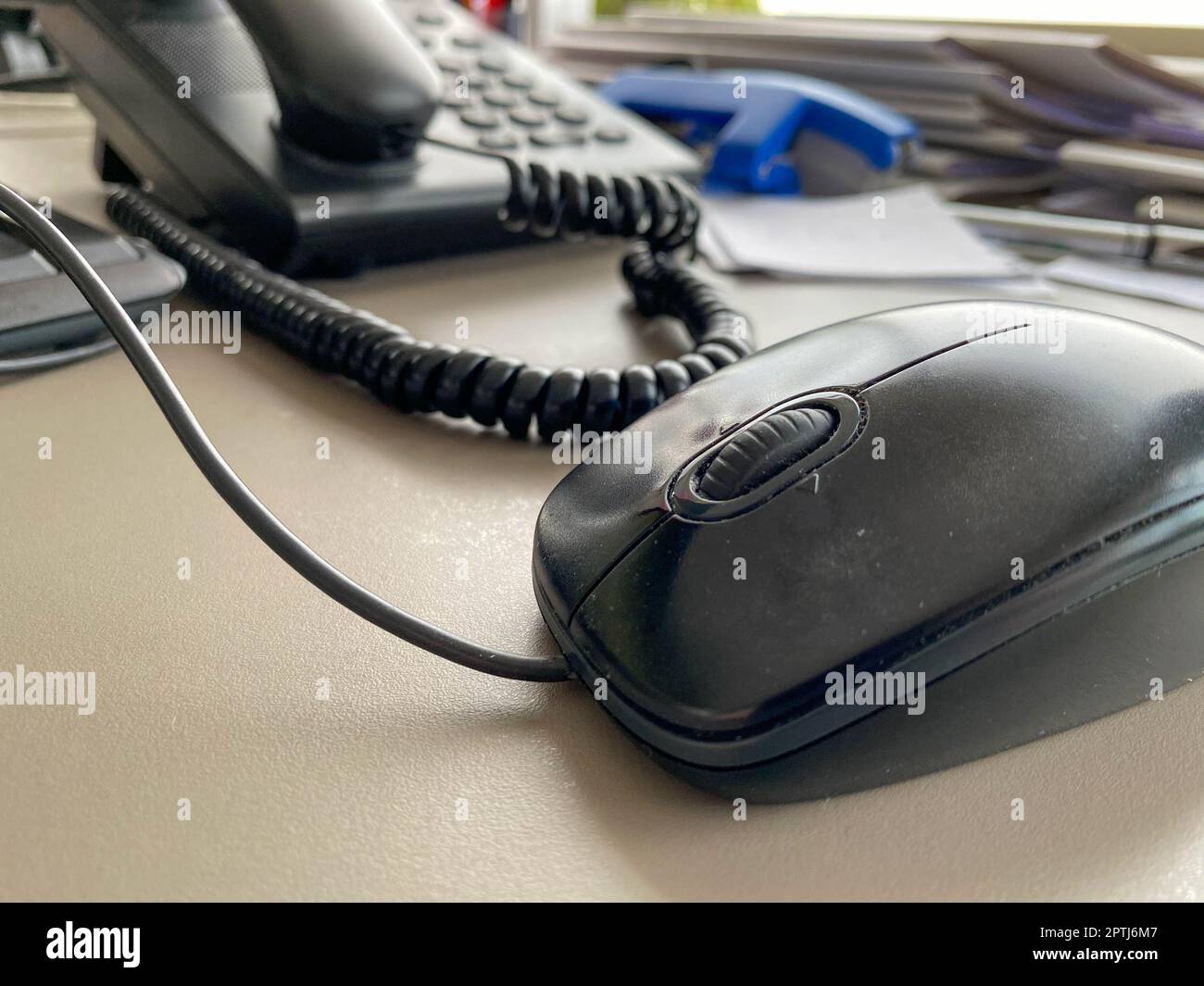 Black landline telephone with a tube, buttons and a wire on the work ...