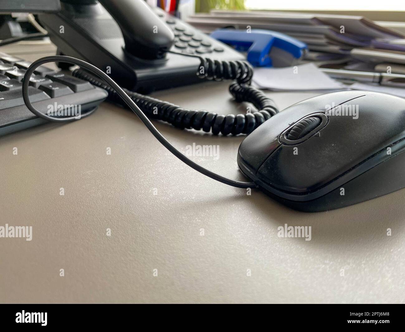 Black landline telephone with a tube, buttons and a wire on the work ...