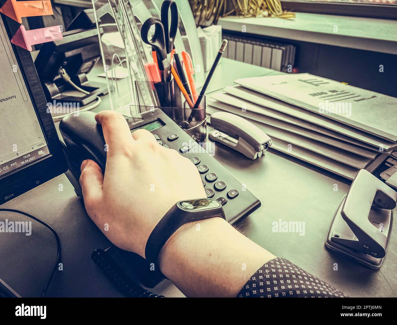 office work. a man in a business blue shirt and a fitness bracelet ...
